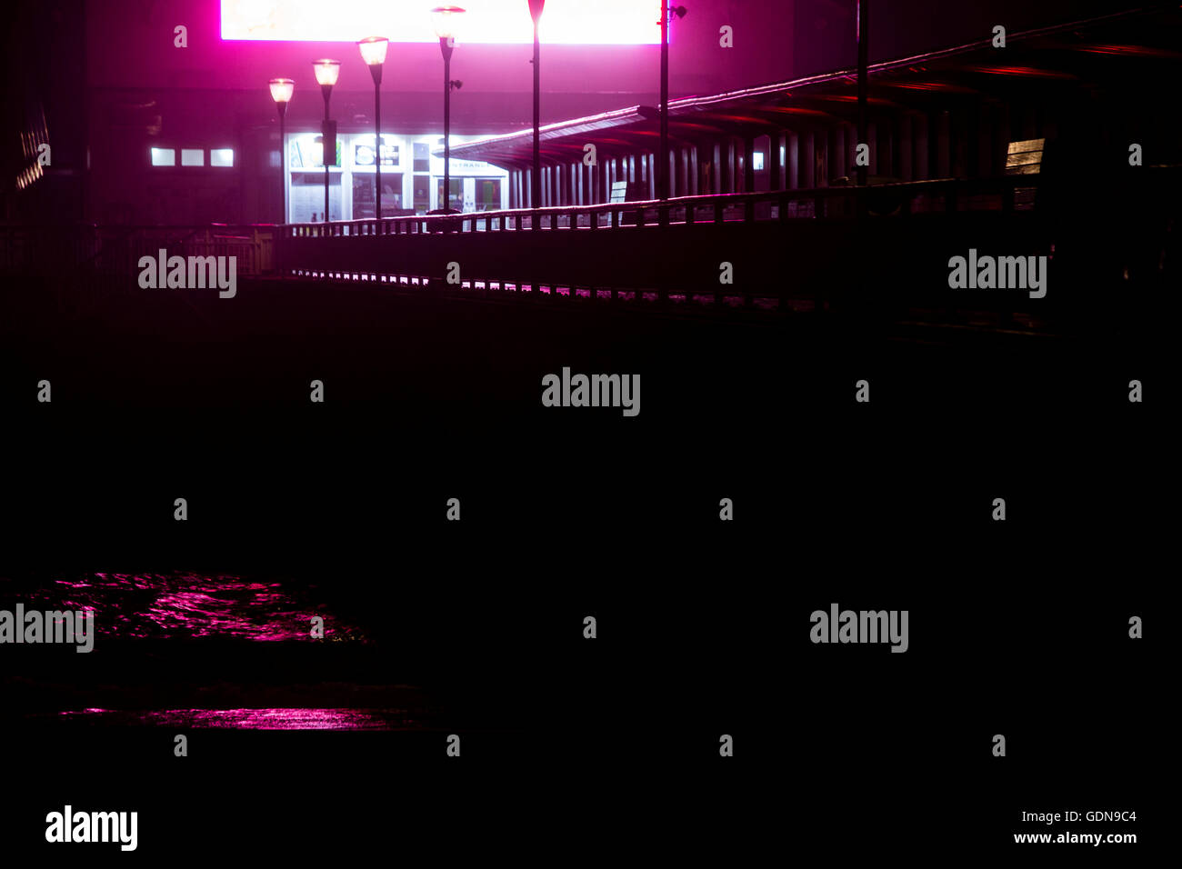 Night time on Bournemouth pier with coloured lights reflecting on in ...