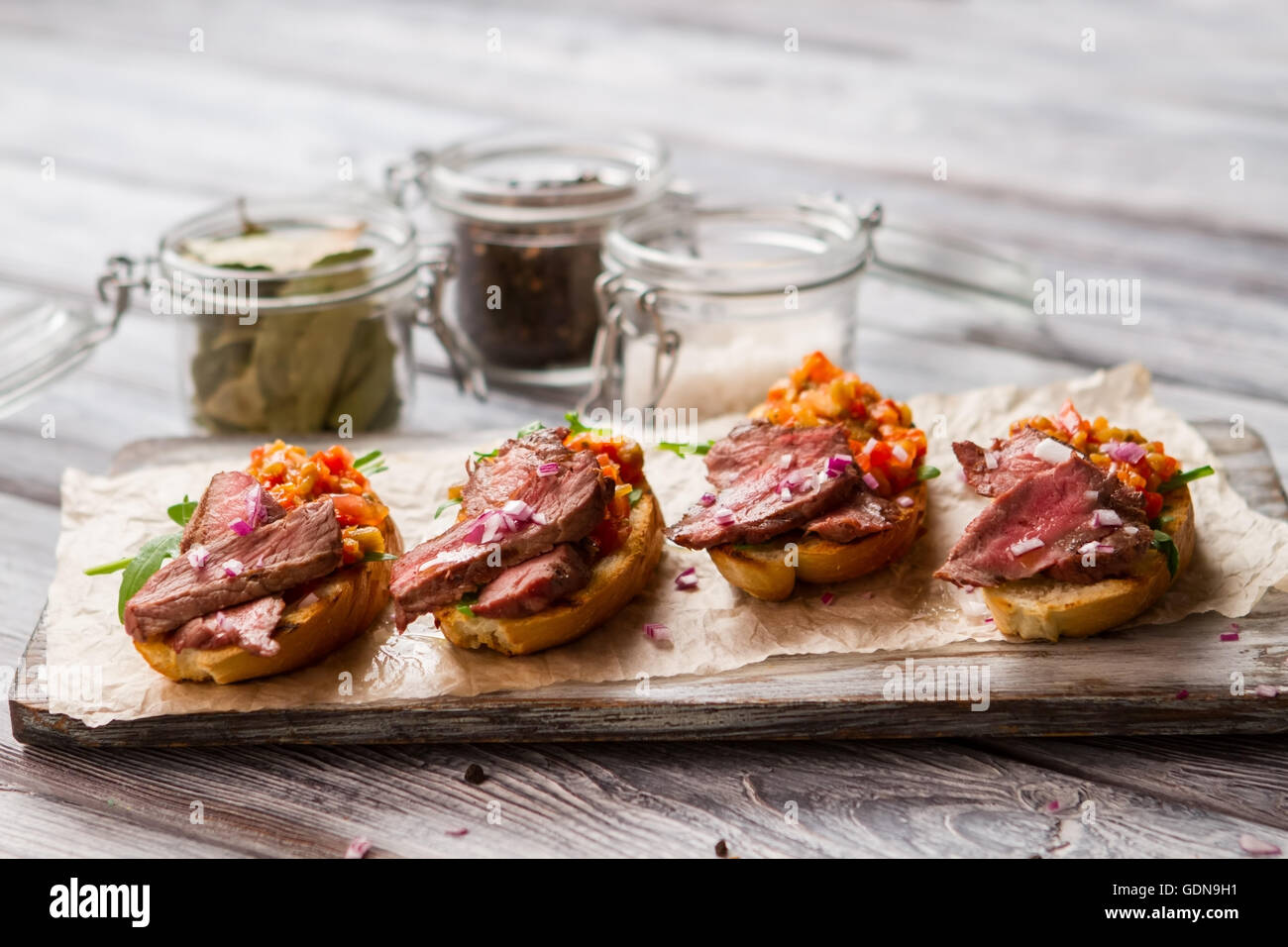Pieces of meat on toasts Stock Photo - Alamy