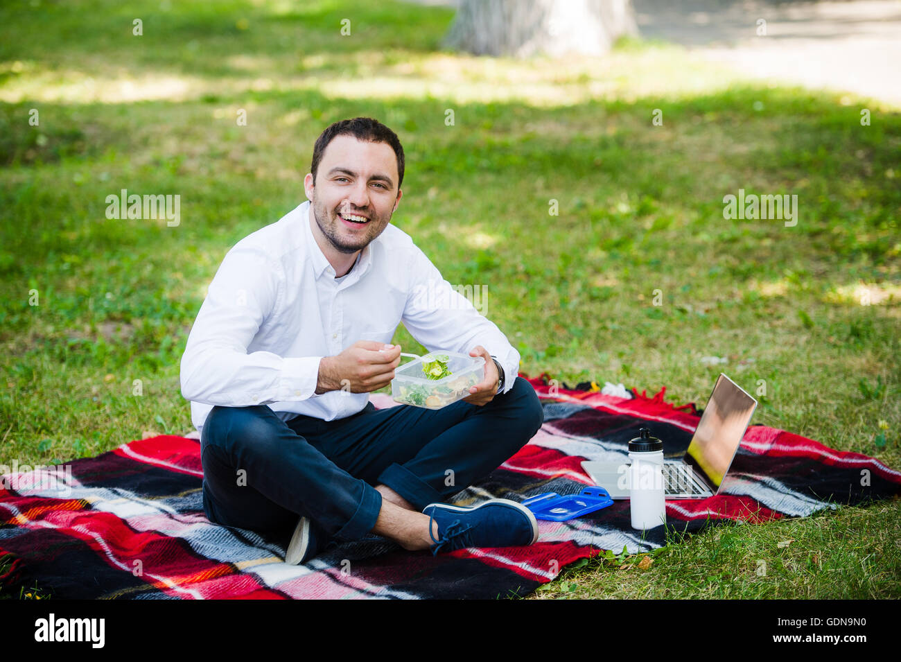young business man enjoying food which he brought in a lunch box from ...