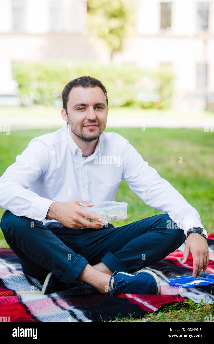 young business man enjoying food which he brought in a lunch box from ...