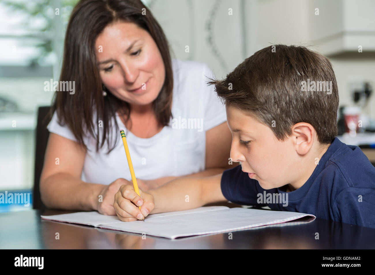 Mother Helping Son With Homework At Table Stock Photo - Alamy