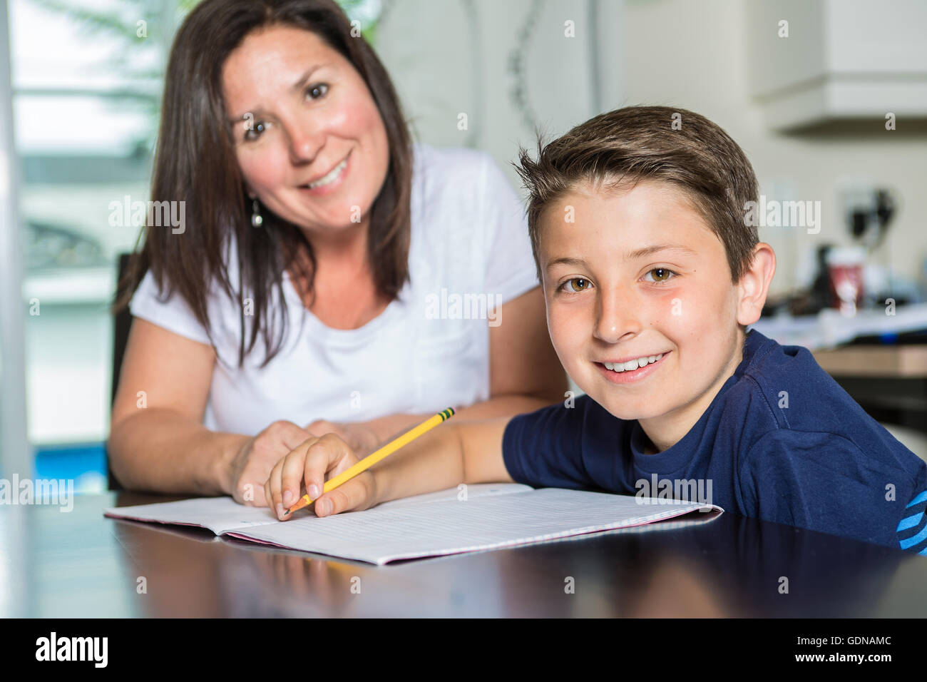 Mother Helping Son With Homework At Table Stock Photo - Alamy