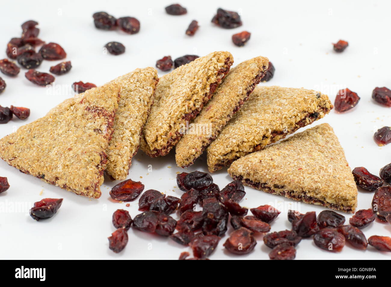 Integral triangle cookies with red raisins on white table Stock Photo ...