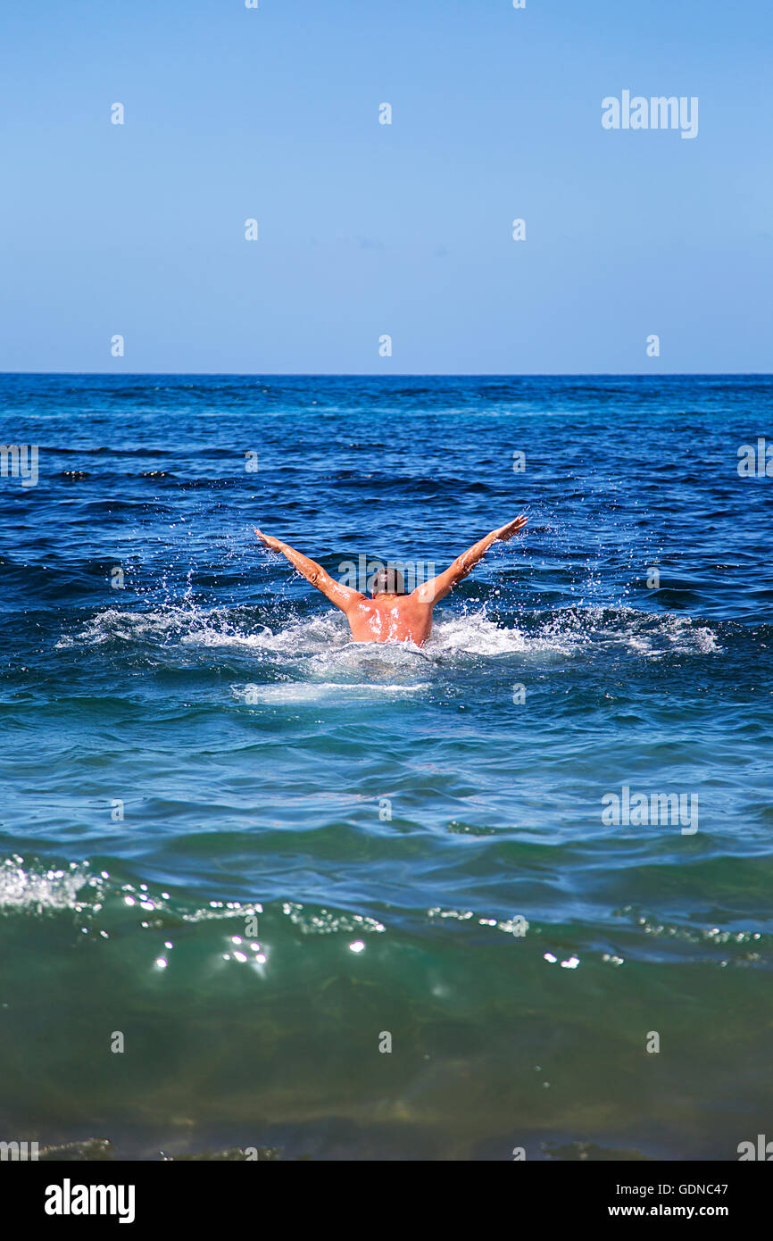 A muscular man swims in the water of sea Stock Photo - Alamy