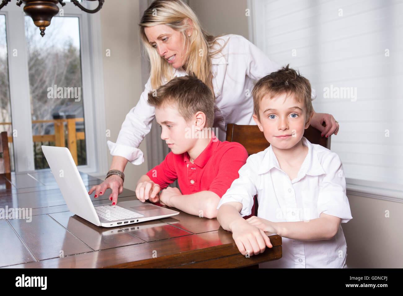Mother with kids playing on laptop computer Stock Photo - Alamy
