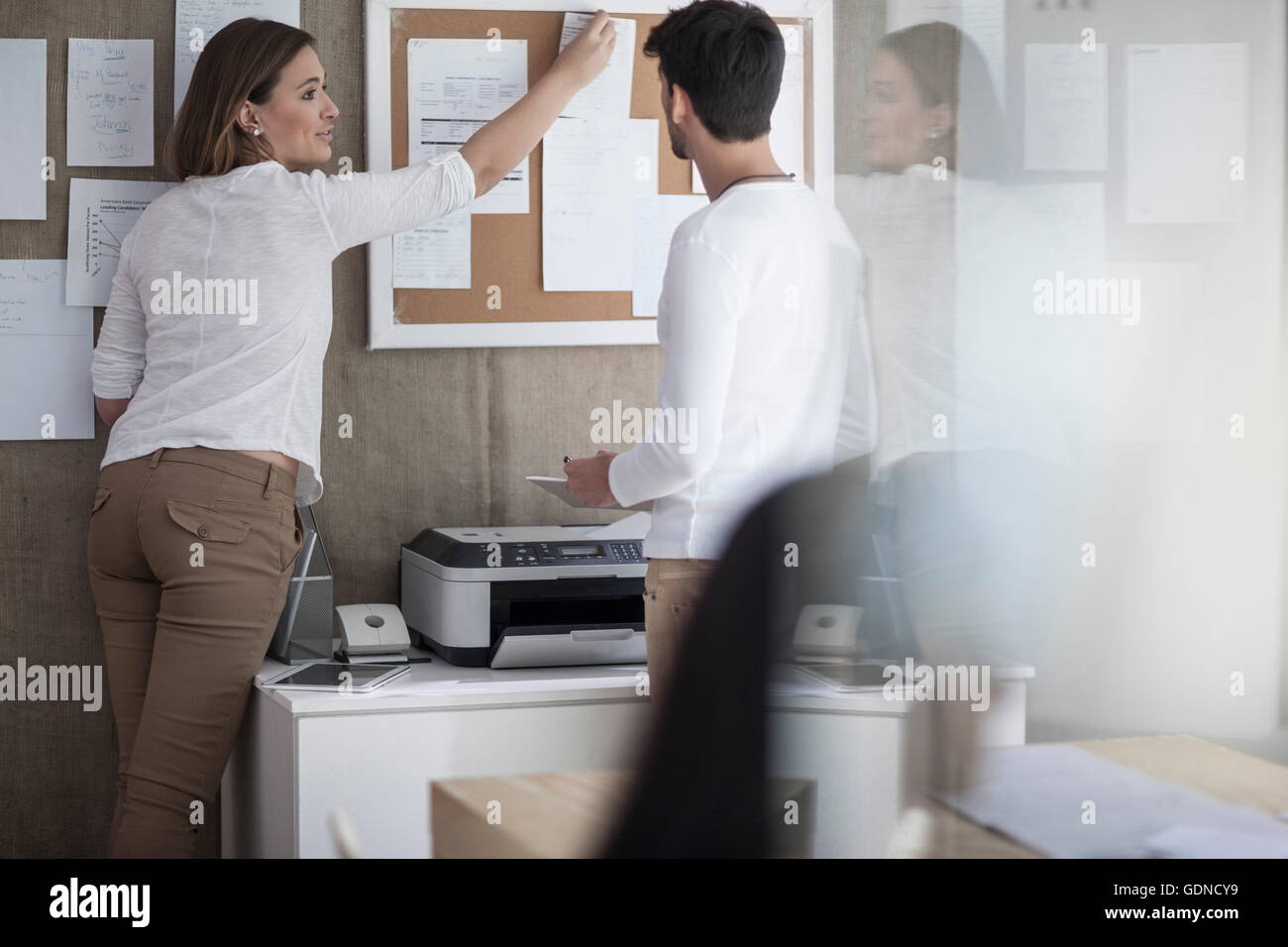 Female designer pinning plans on notice board in design studio Stock ...