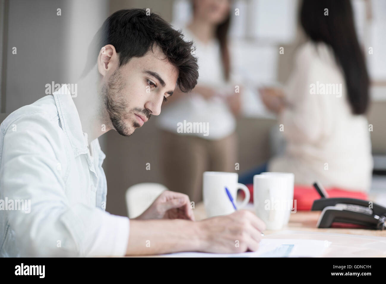 Young male designer working on blueprint in design studio Stock Photo ...