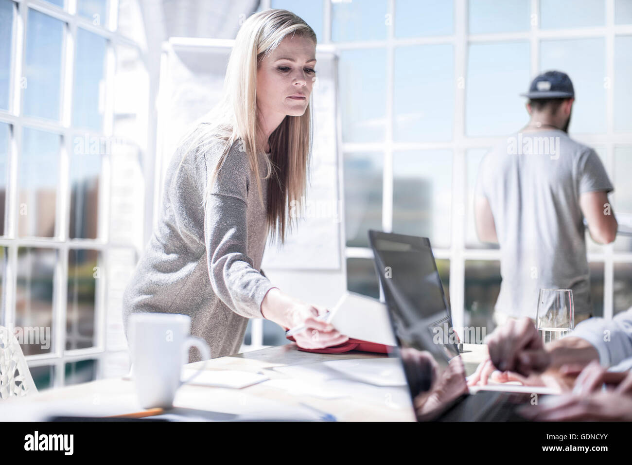 Female designers handing over paperwork in design studio Stock Photo ...