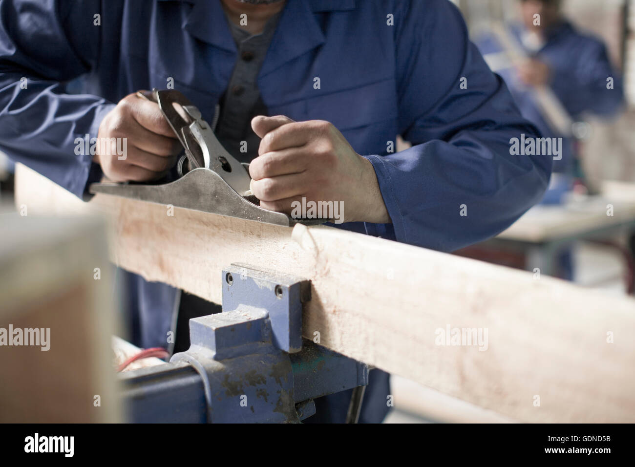 Hands of carpenter using planer on plank in workshop Stock Photo - Alamy