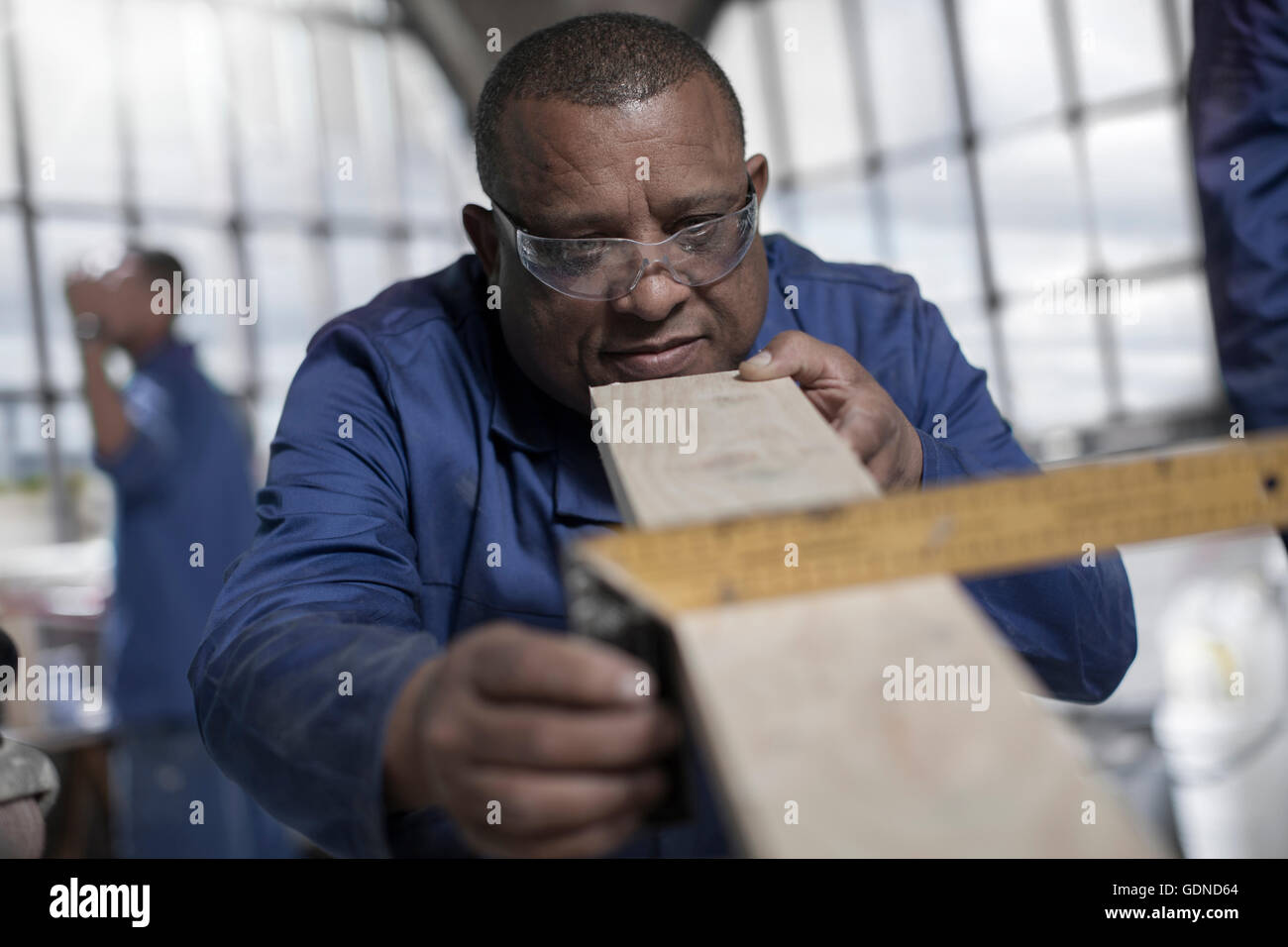 Carpenter measuring angle of plank in workshop Stock Photo - Alamy