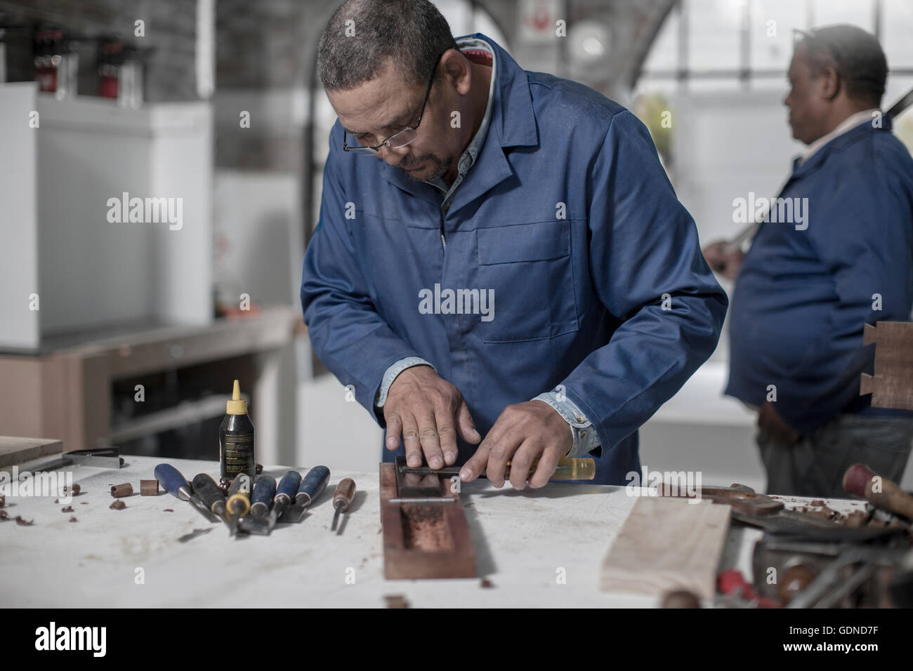 Carpenter using chisel in wood workshop Stock Photo - Alamy