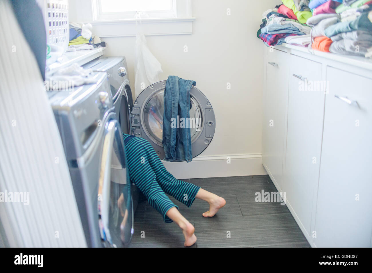 Legs of boy in washing machine Stock Photo - Alamy