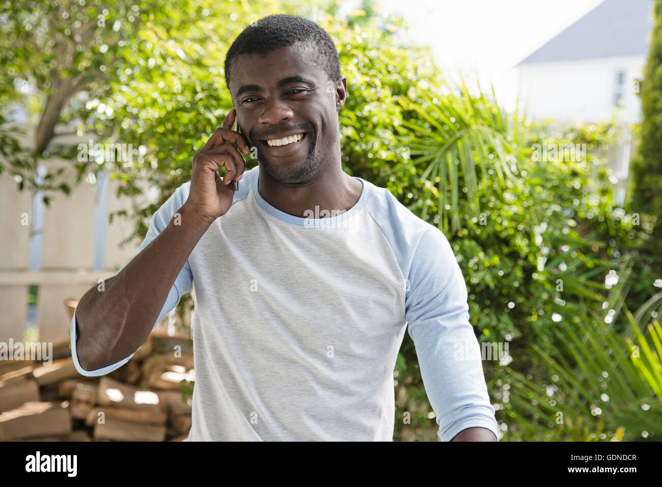 Man using mobile phone in garden Stock Photo - Alamy