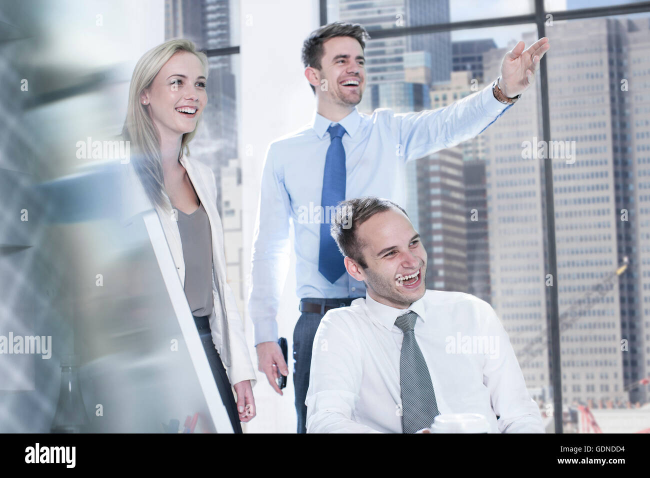 Businessmen and businesswoman laughing in office Stock Photo - Alamy