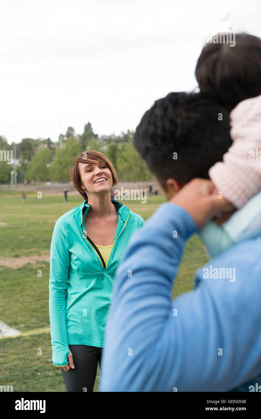 Couple playing piggyback ride with baby in park Stock Photo - Alamy