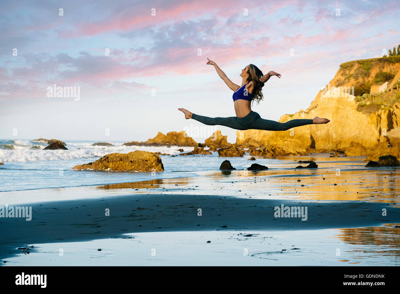Young female ballet dancer jumping mid air on beach, Los Angeles ...