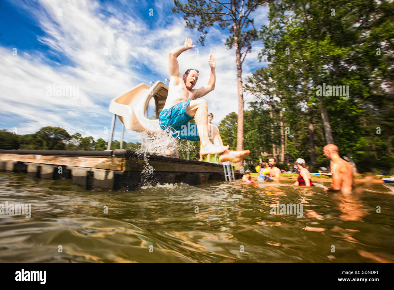 Man jumping from pier slide at Jackson Lake, Georgia, USA Stock Photo ...
