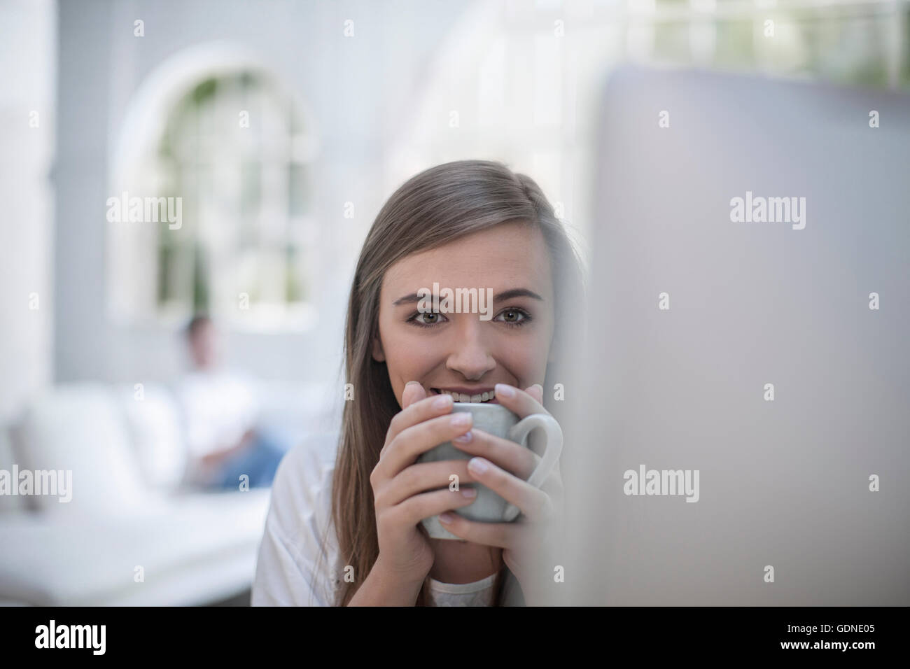 Woman drinking coffee in front of computer Stock Photo - Alamy