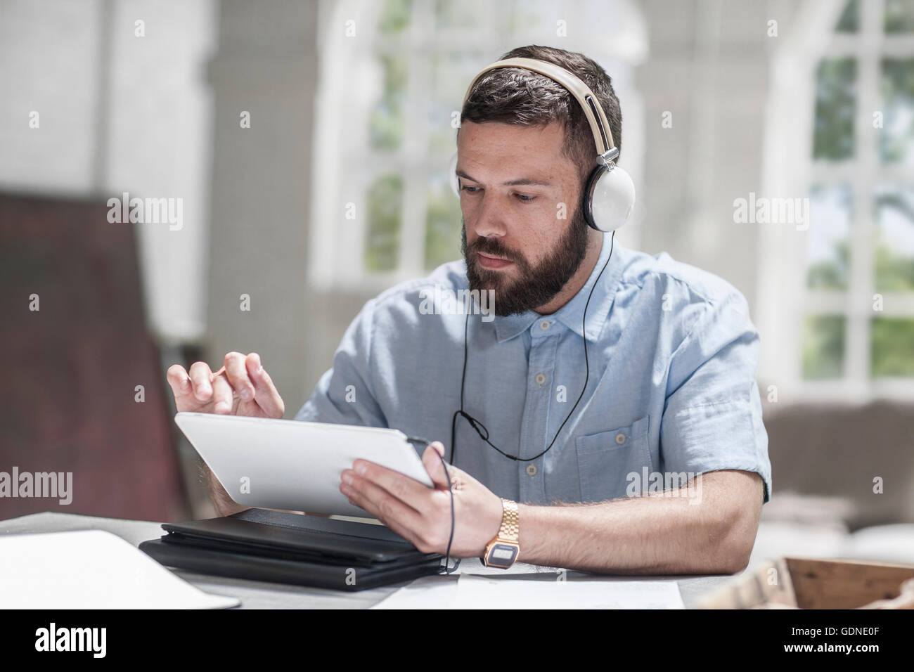 Man using digital tablet with headphones Stock Photo - Alamy