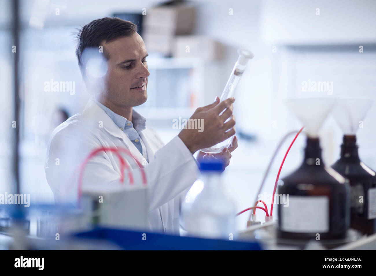 Mid adult man in laboratory, holding test tube Stock Photo - Alamy