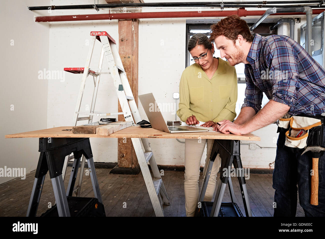 Carpenter and client using laptop Stock Photo - Alamy
