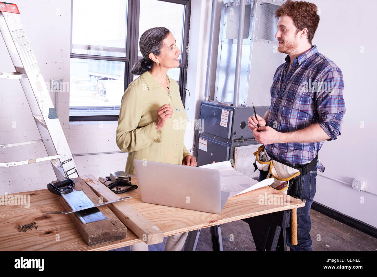 Carpenter and client discussing blueprint Stock Photo - Alamy
