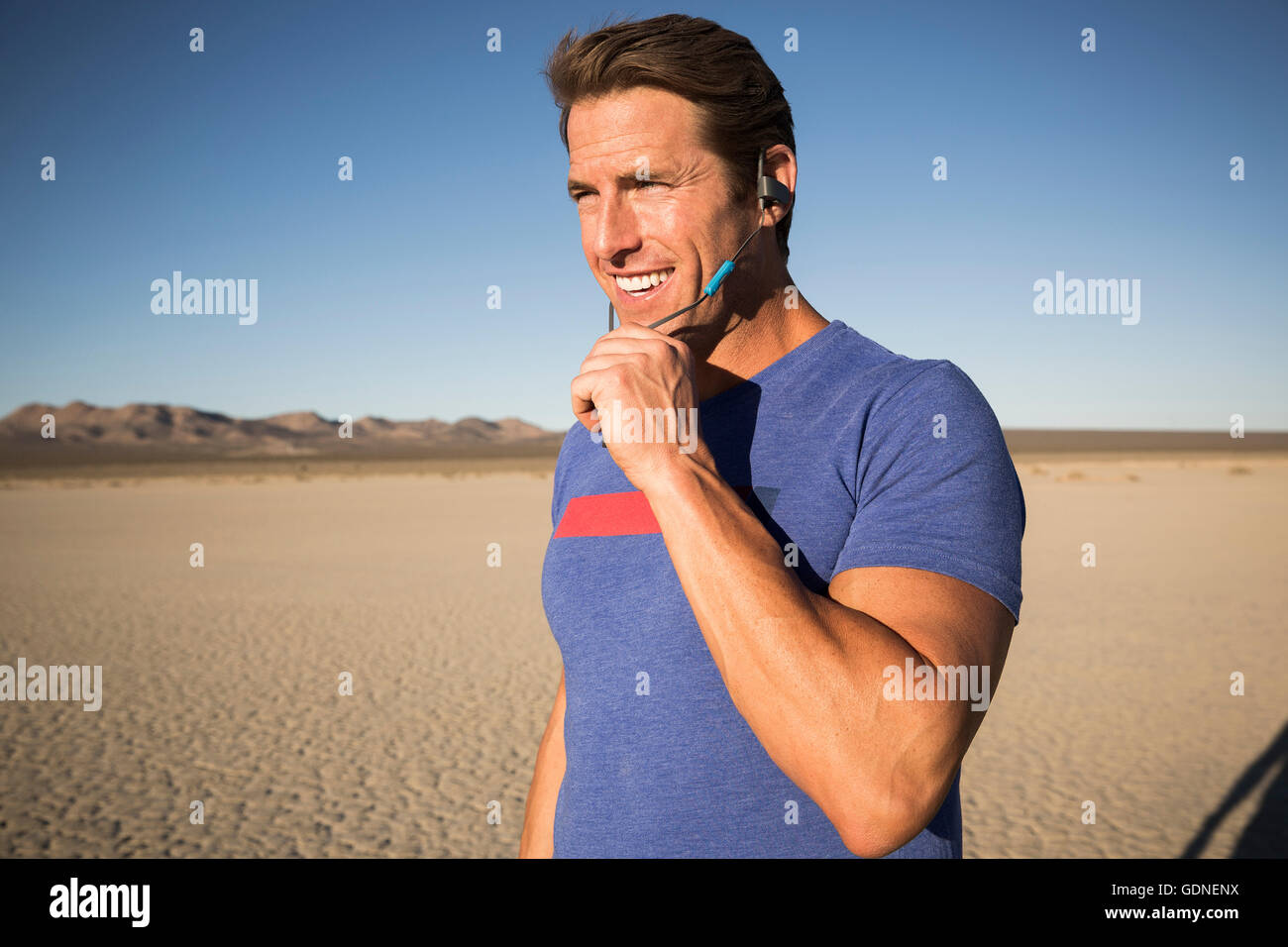 Man training, talking to bluetooth headset on dry lake bed, El Mirage ...