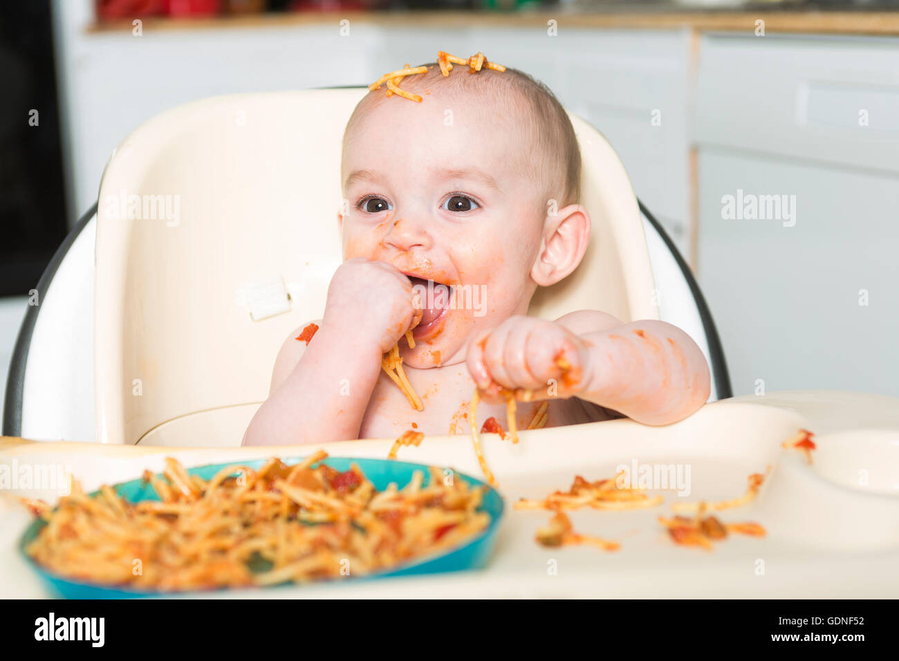 Little b eating her dinner and making a mess Stock Photo - Alamy