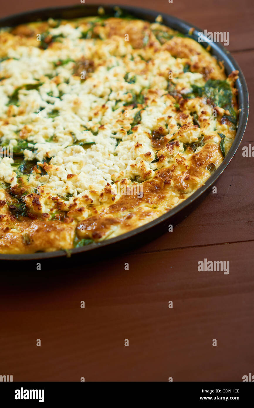 Frittata baked in a pan, on a rustic wooden table, ready to eat Stock ...