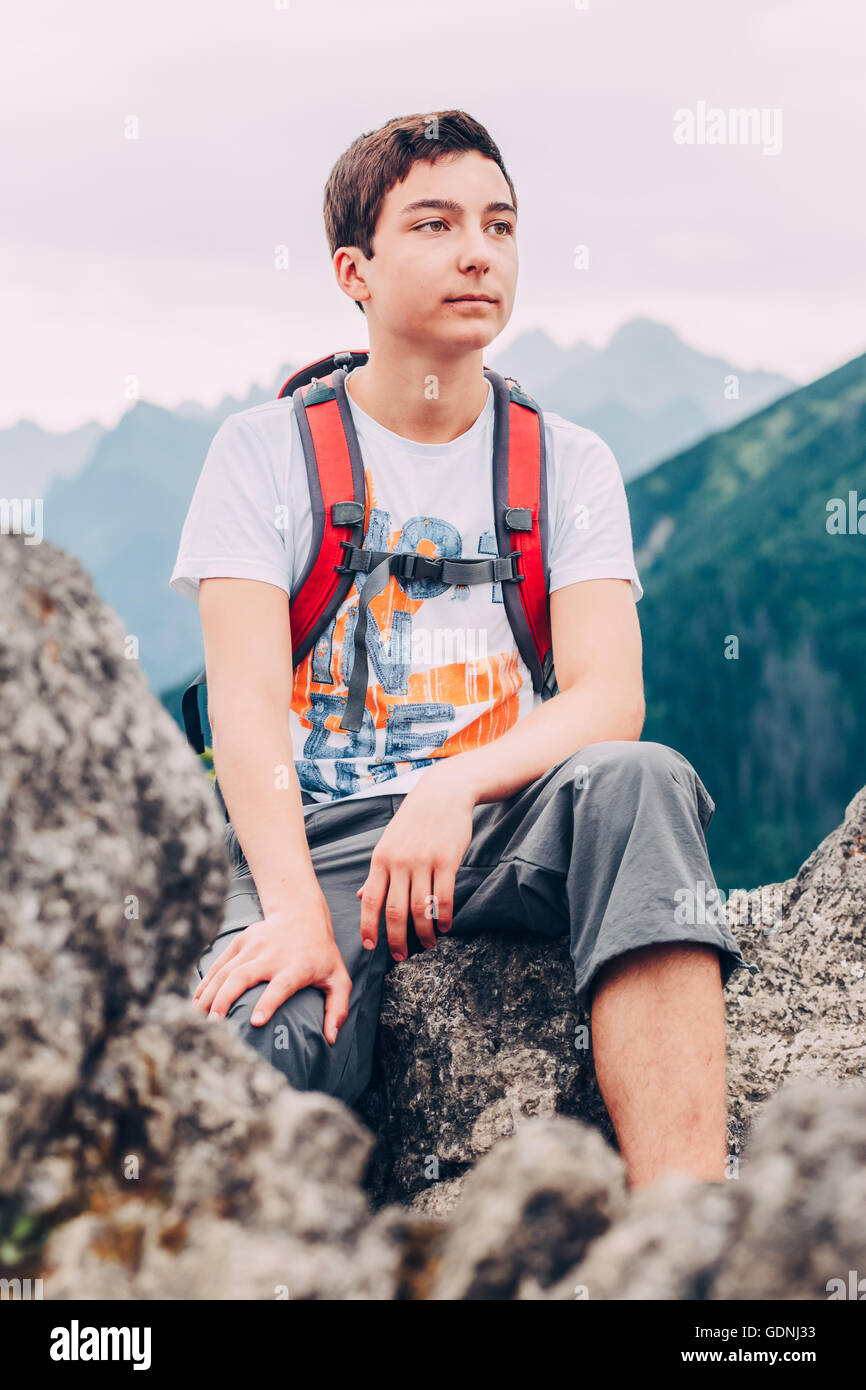 Boy sitting on the rocks in the mountains Stock Photo - Alamy