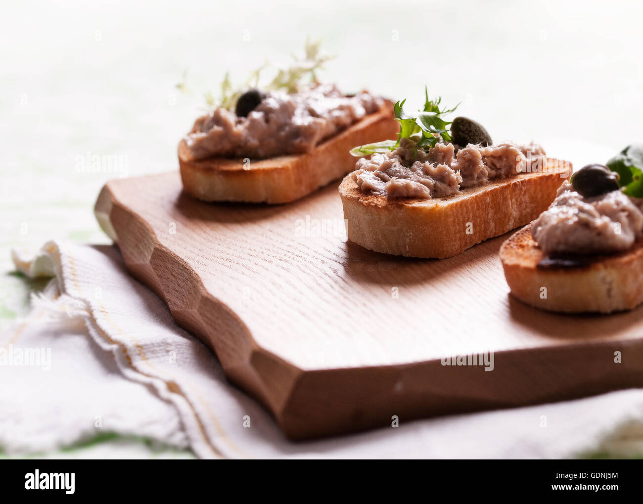 Fish pate spread with toast on a wood board Stock Photo - Alamy