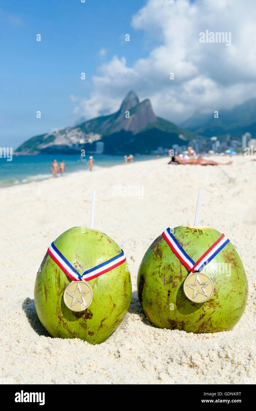 Two green Brazilian coco gelado drinking coconuts wear gold medals on ...