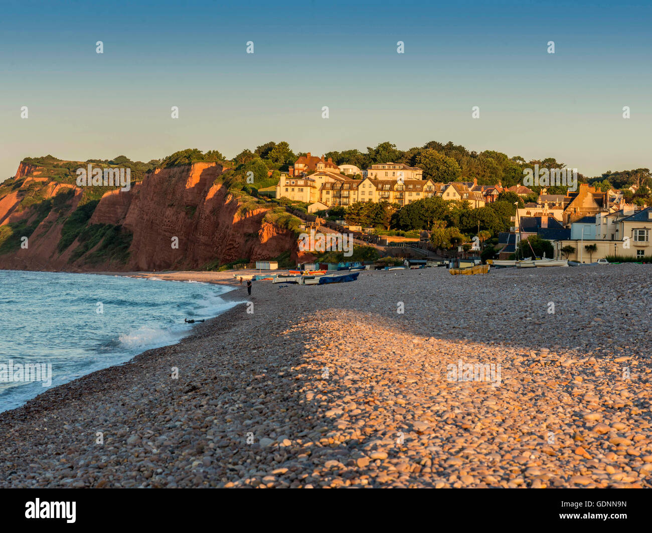 Landscape depicting sunrise over quaint seaside village, featuring ...