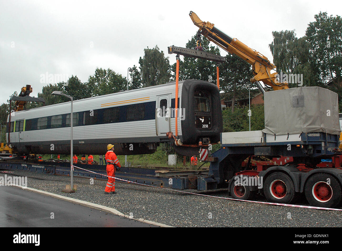 Two cranes lift a railway carriage off the tracks to be placed on a ...