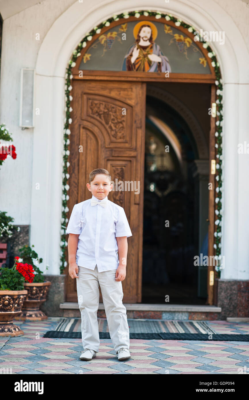 Portrait of little boy on white wear and bow tie on first holy ...
