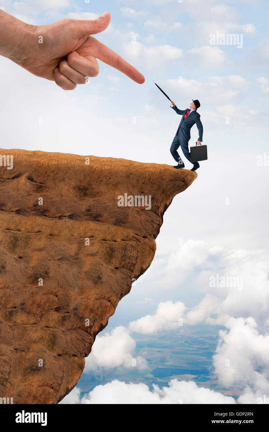 business challenge concept businessman pushed to the edge of a cliff ...