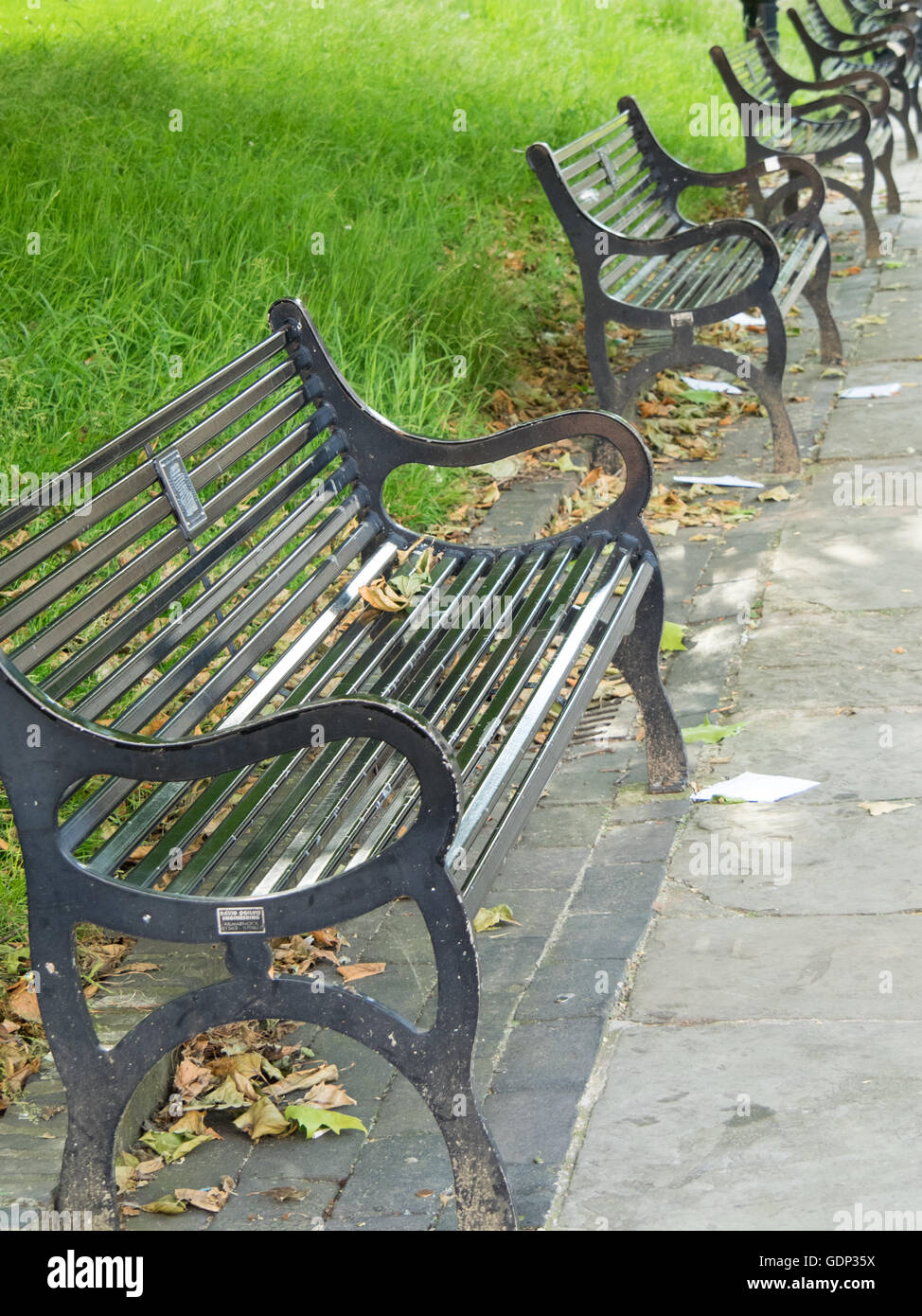 A line of metal park benches along a path in St Paul's Square ...