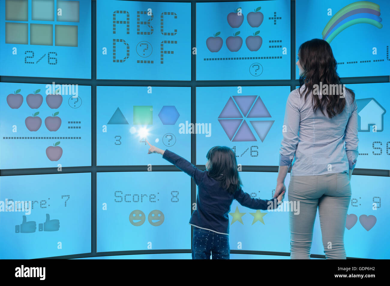 Mother and daughter standing in front of graphical screens showing ...