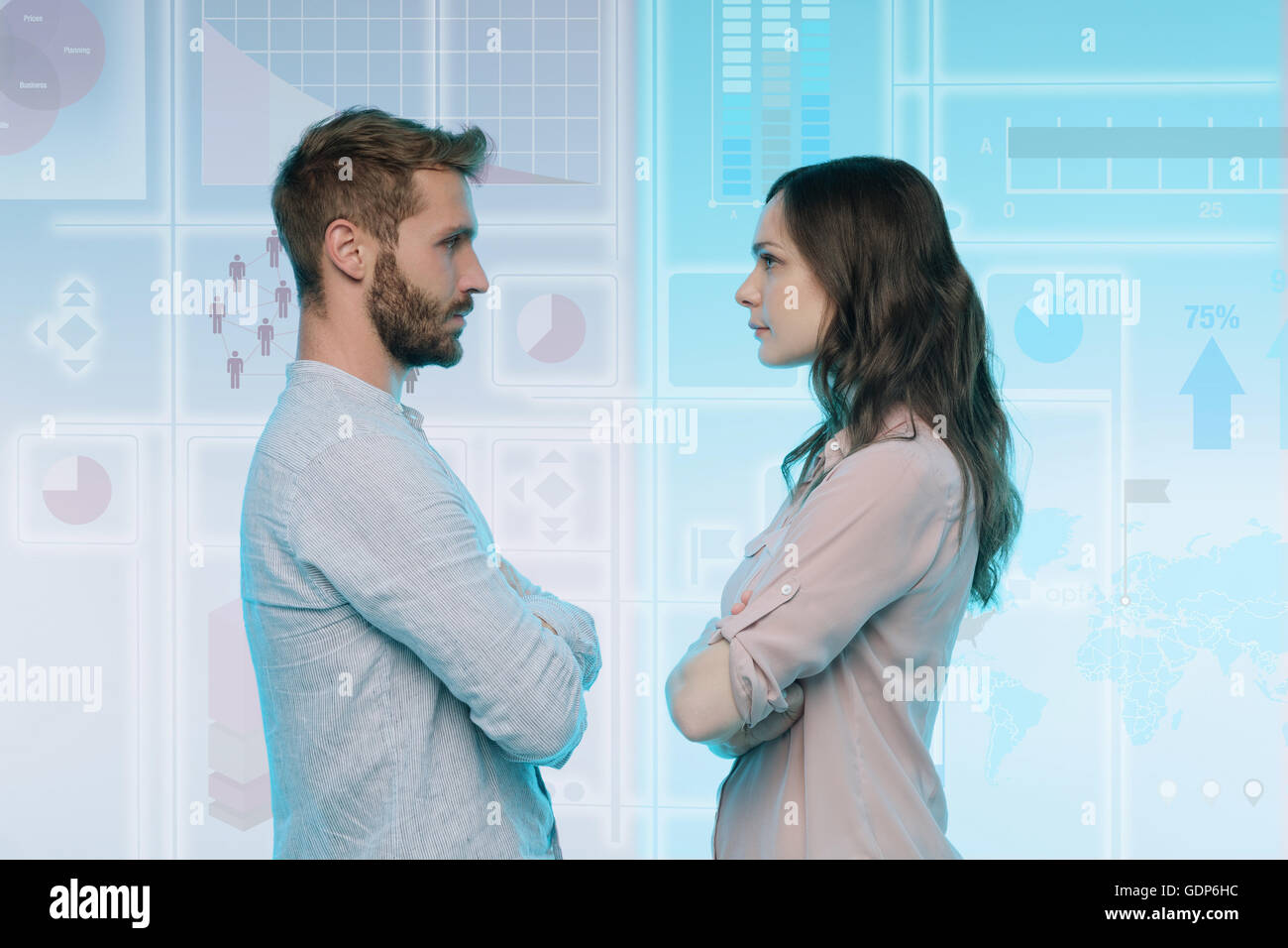 Man and woman standing face to face, data on graphical screen behind ...