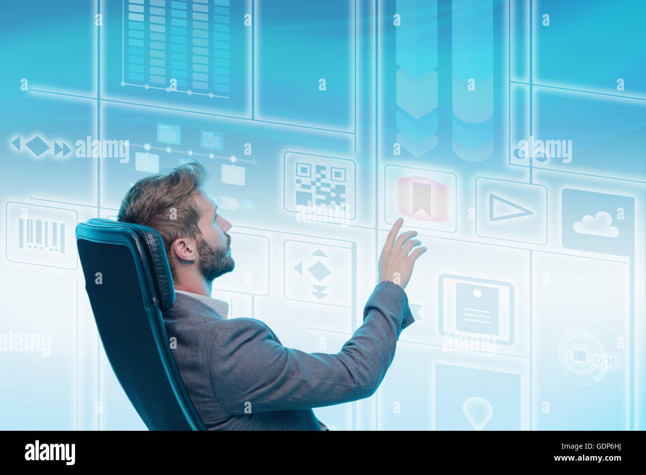 Man sitting in chair, using graphical screen, touching screen Stock ...