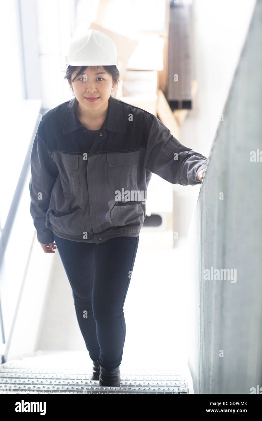 Worker walking up staircase in factory Stock Photo - Alamy