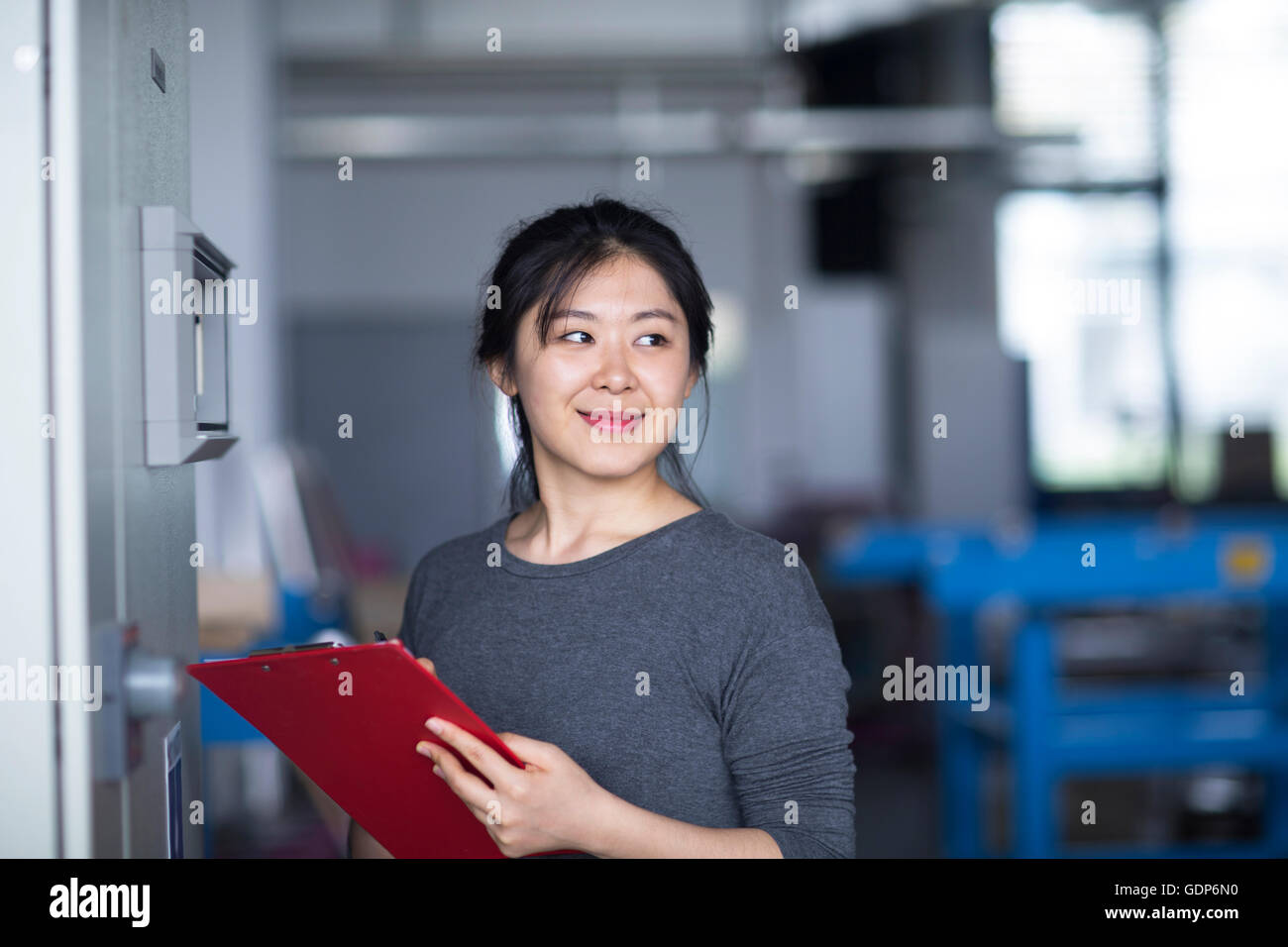 Worker holding clipboard in factory Stock Photo - Alamy