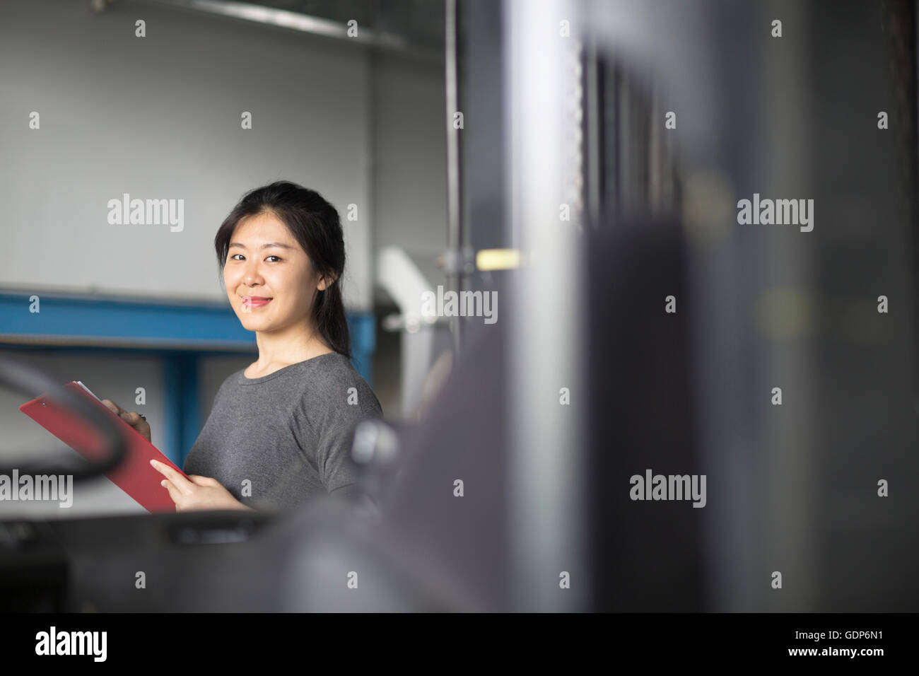 Worker holding clipboard in factory Stock Photo - Alamy