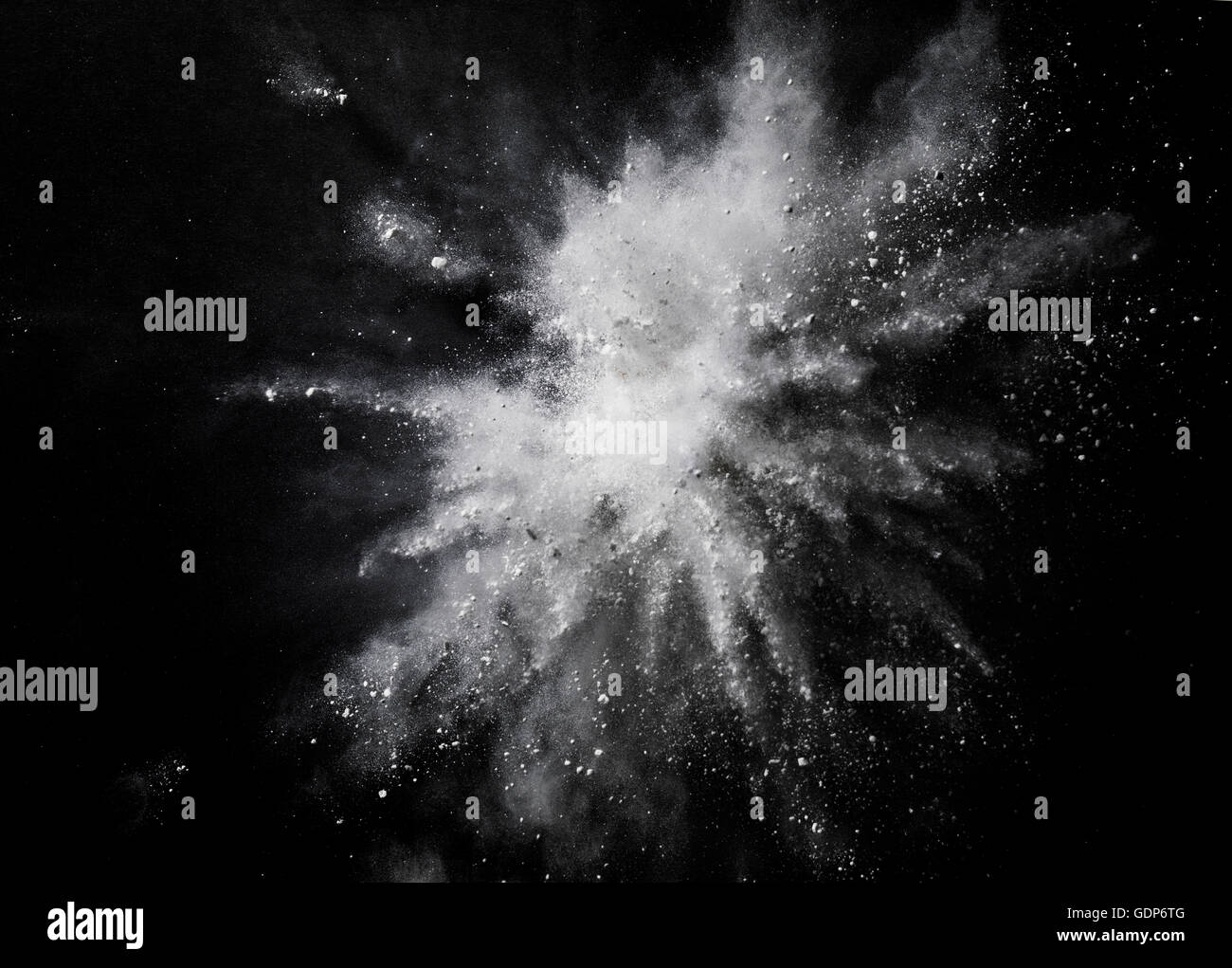 White dust exploding mid air against black background Stock Photo - Alamy