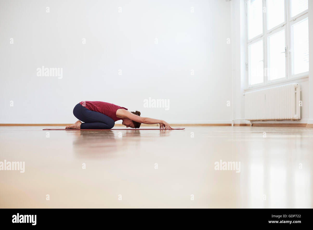 Side view of woman in exercise studio head down bending forward Stock ...