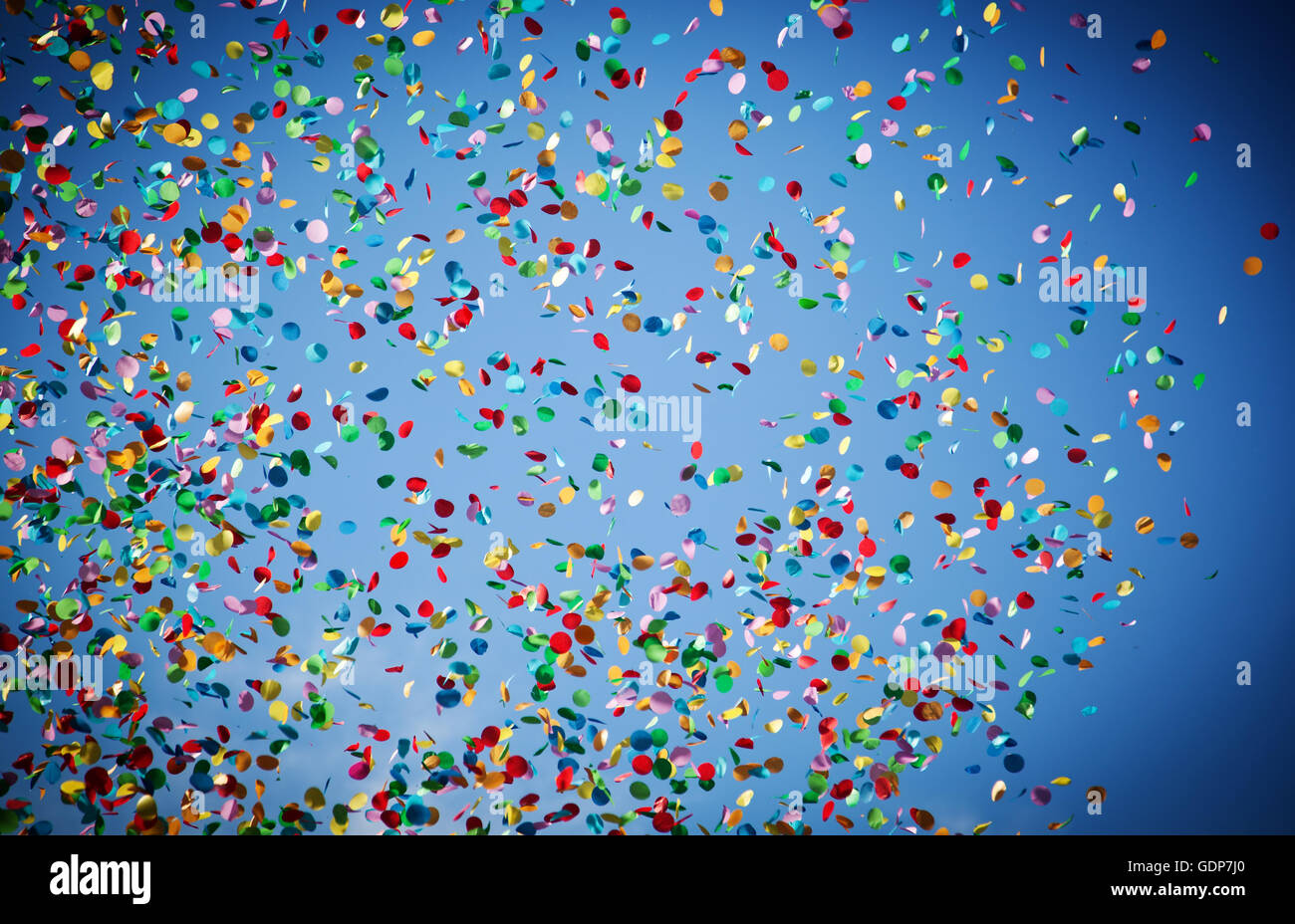 falling confetti in the city festival on blue sky background Stock Photo - Alamy