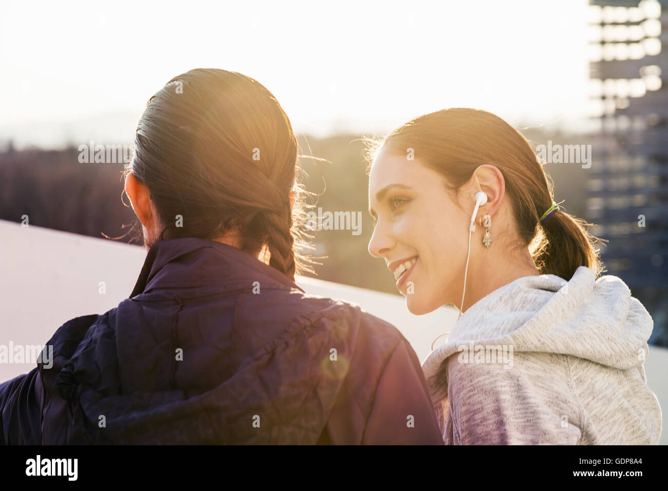Two female friends outdoors, smiling, rear view Stock Photo - Alamy