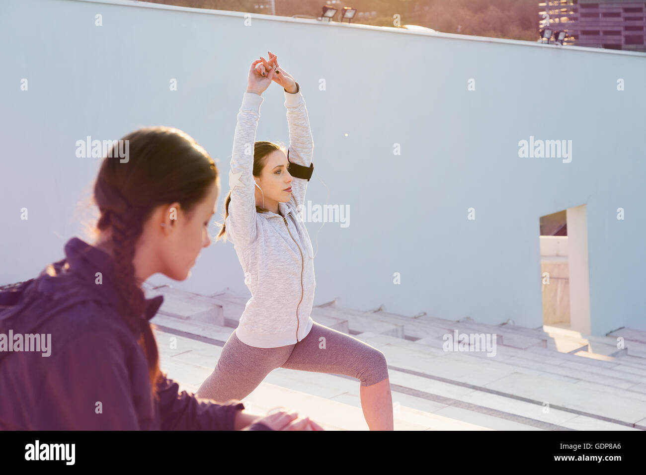 Two female friends exercising outdoors, stretching Stock Photo - Alamy