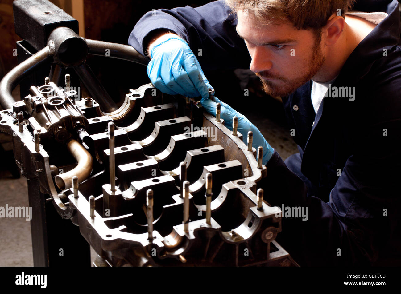 Male mechanic analysing car engine, stripped from car Stock Photo - Alamy