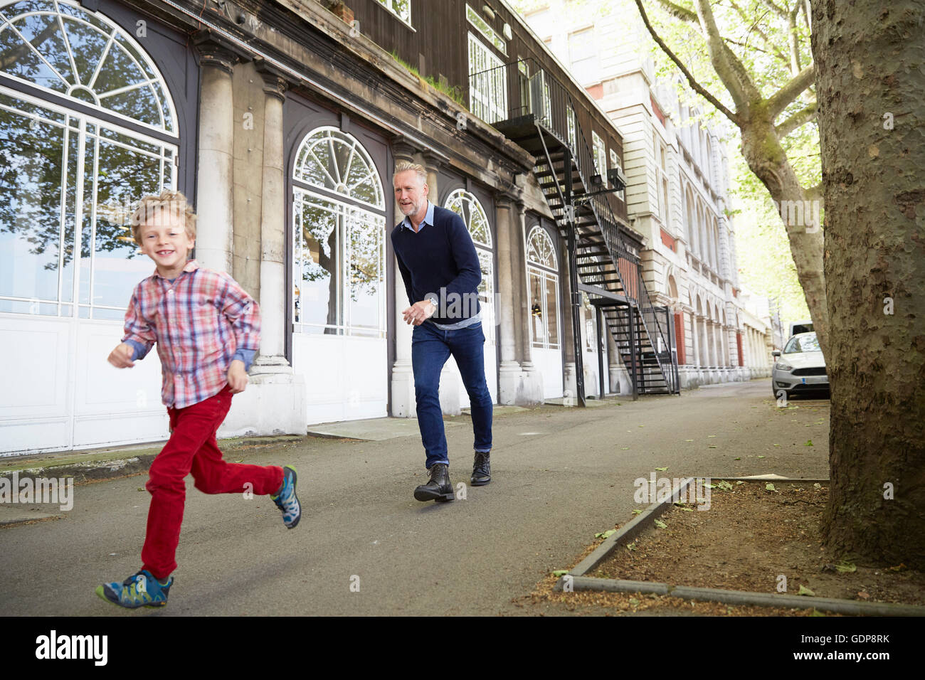 Father and son running in street Stock Photo - Alamy